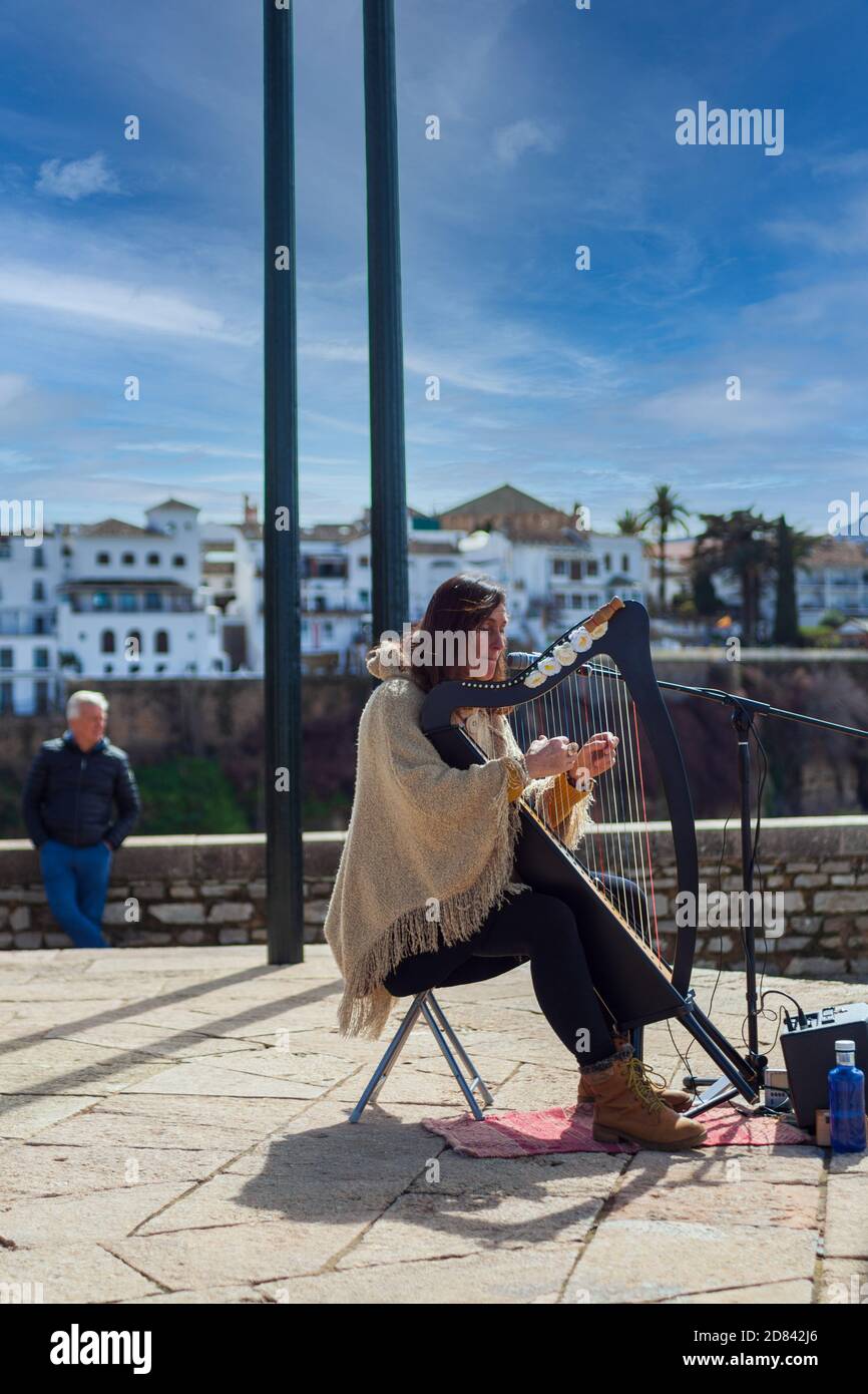 female harpist busker busking in ronda spain Stock Photo - Alamy