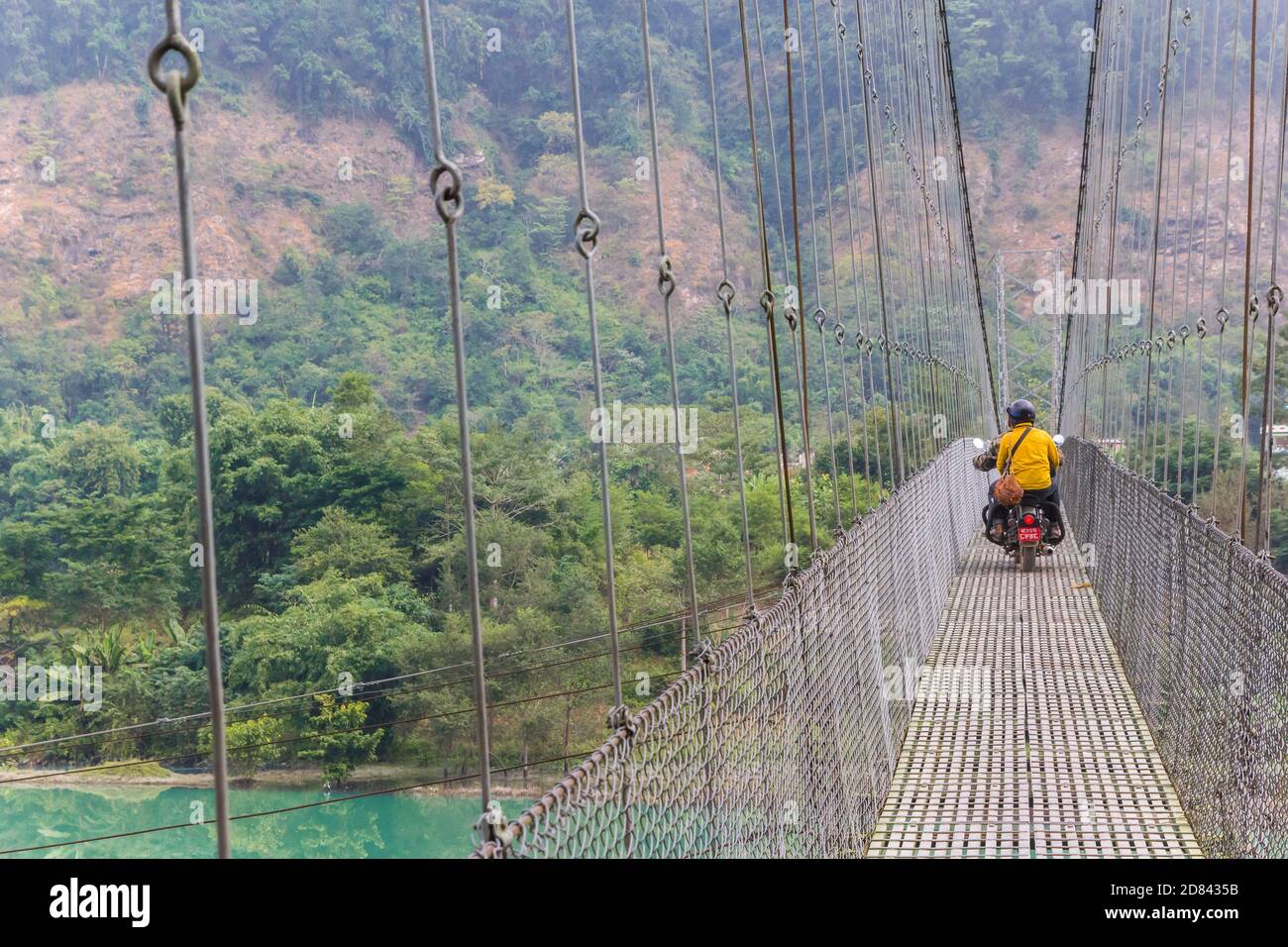 Motorcycle crossing the suspension bridge over the Trishuli river in ...