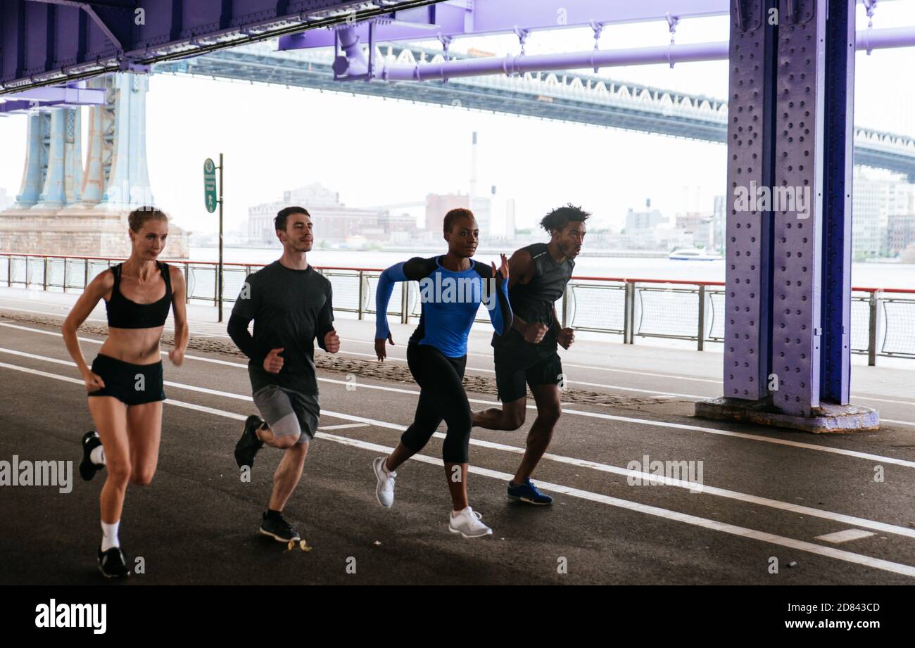 Group of urban runners running on the street in New york city ...