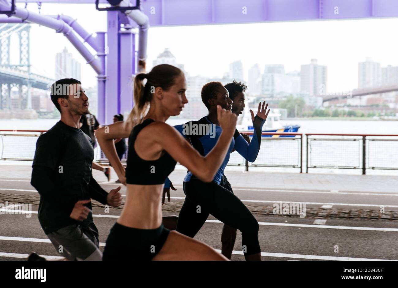 Group of urban runners running on the street in New york city ...