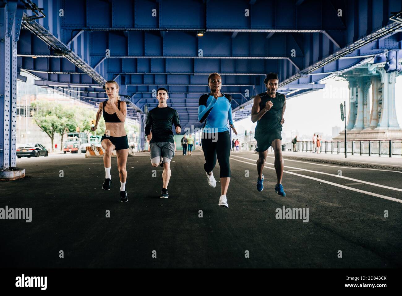 Group of urban runners running on the street in New york city ...