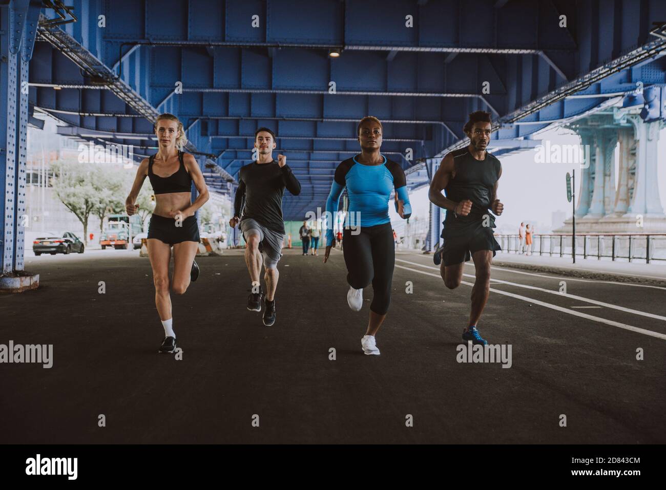 Group of urban runners running on the street in New york city ...
