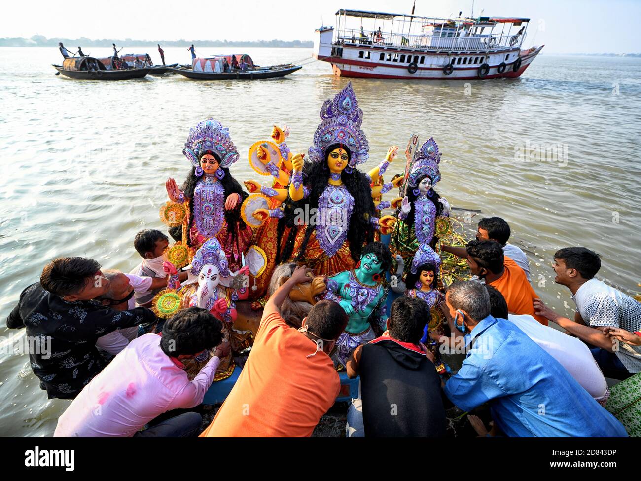 Kolkata, India. 26th Oct, 2020. Hindu devotees submerge a clay idol of ...