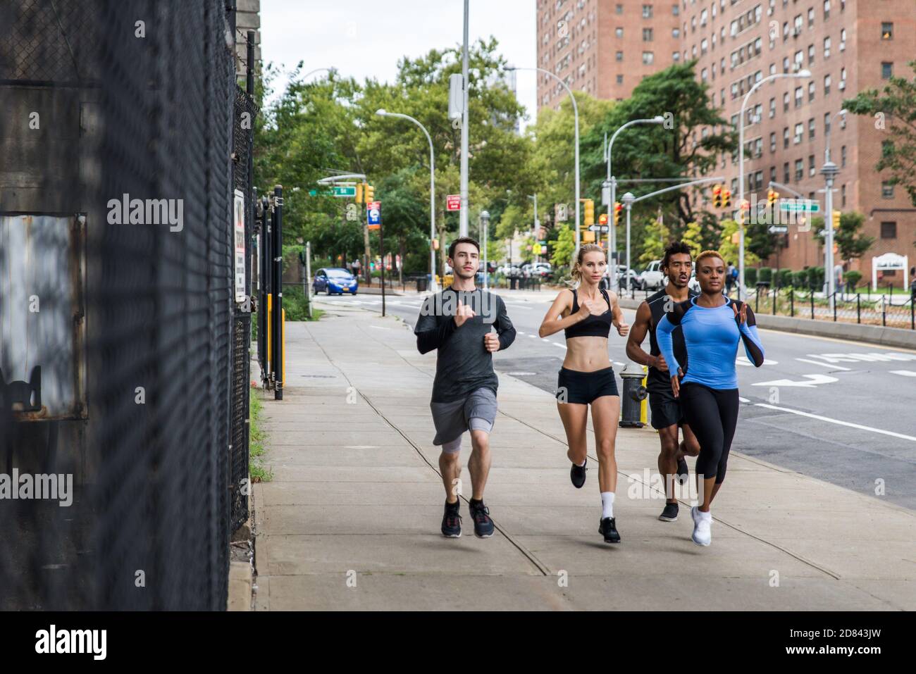 Group of urban runners running on the street in New york city ...