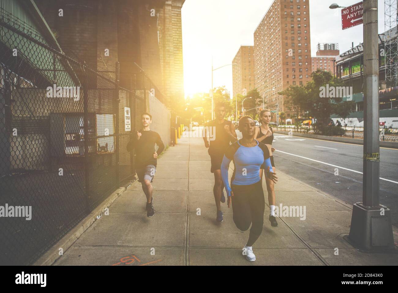 Group of urban runners running on the street in New york city ...