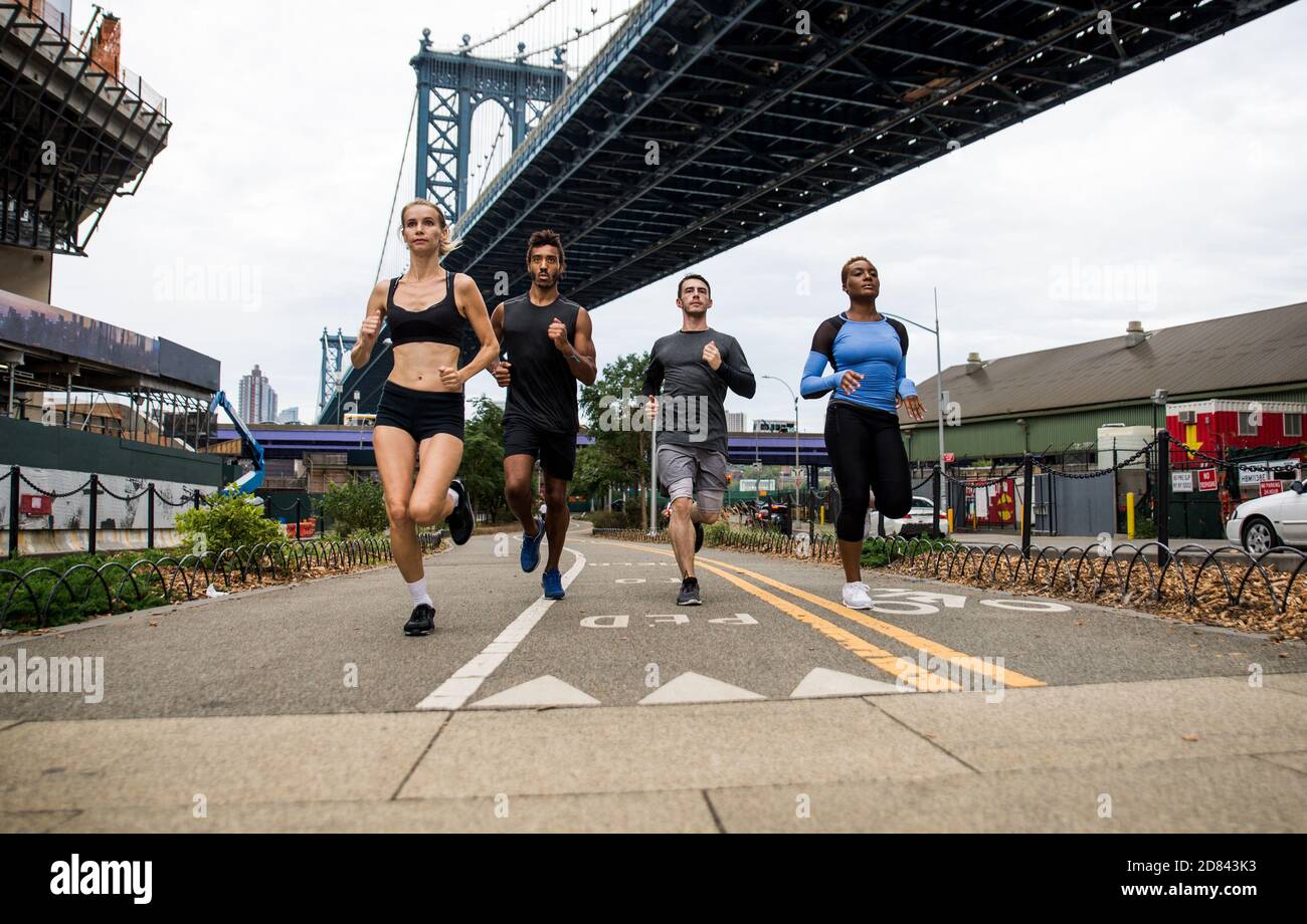 Group of urban runners running on the street in New york city ...