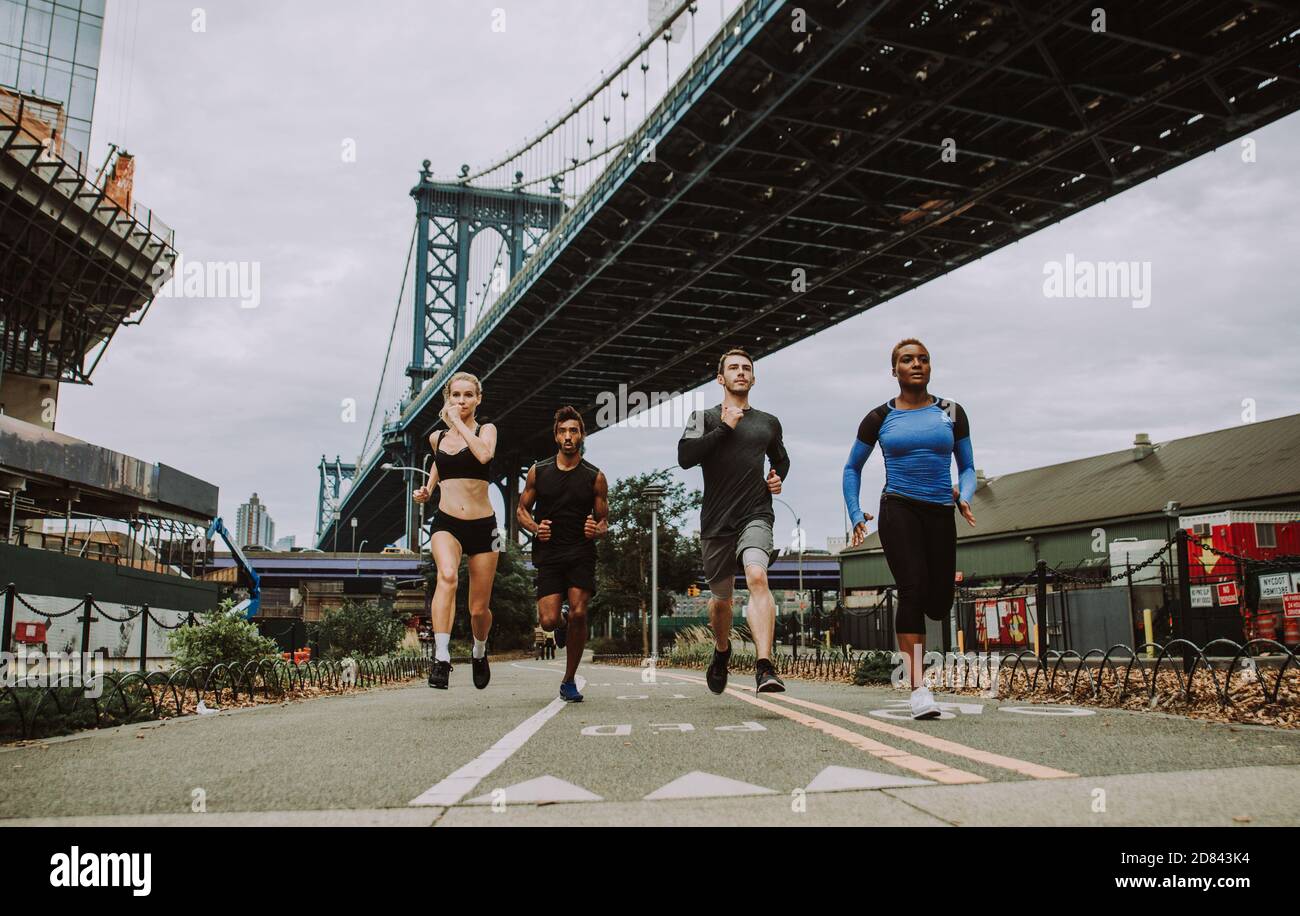 Group of urban runners running on the street in New york city ...