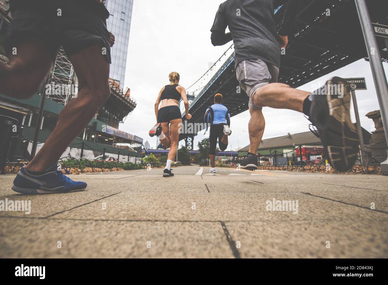 Group of urban runners running on the street in New york city ...