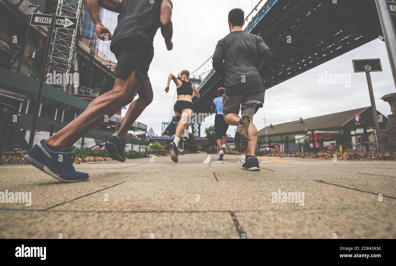 Group of urban runners running on the street in New york city ...