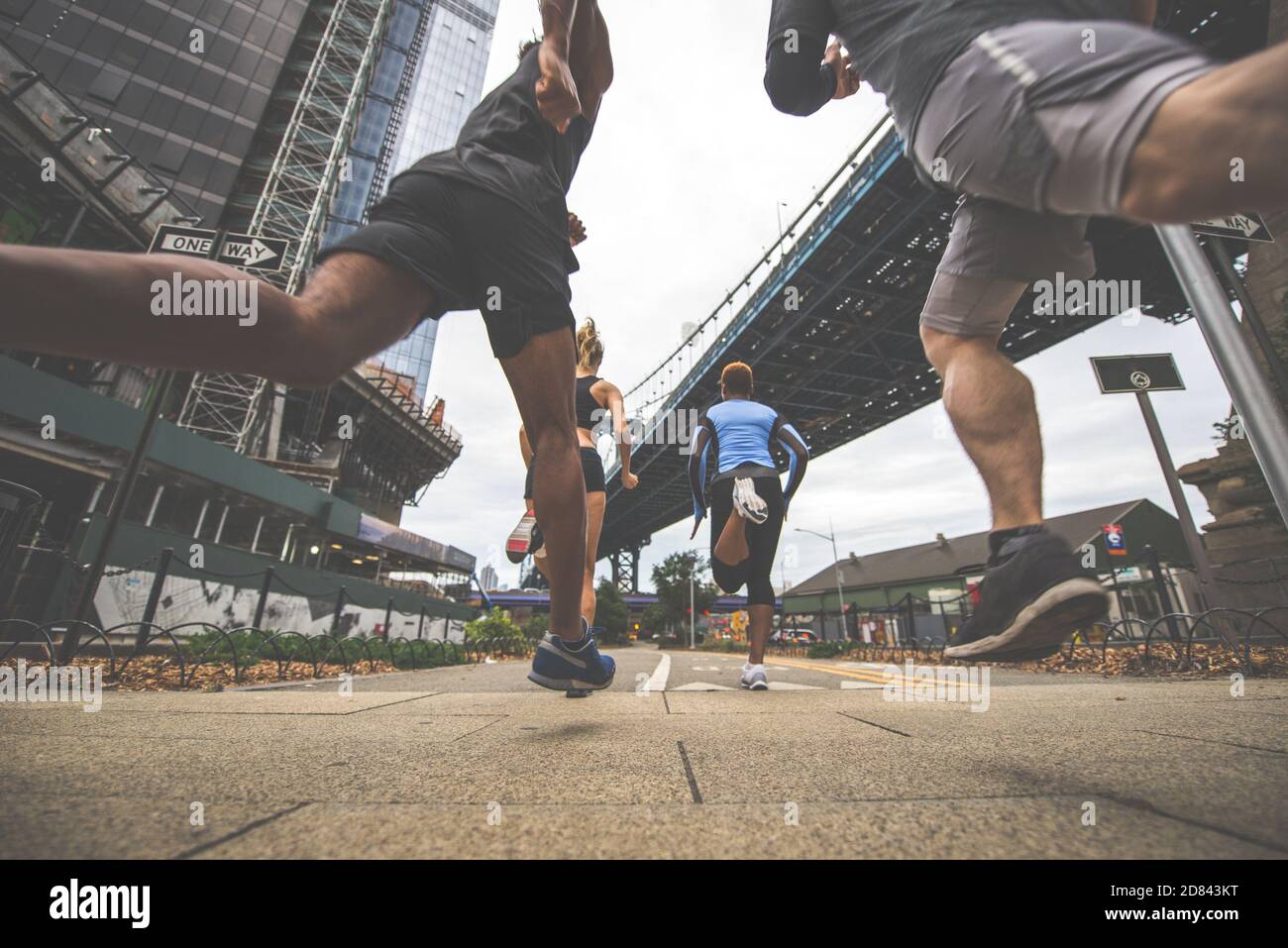 Group of urban runners running on the street in New york city ...
