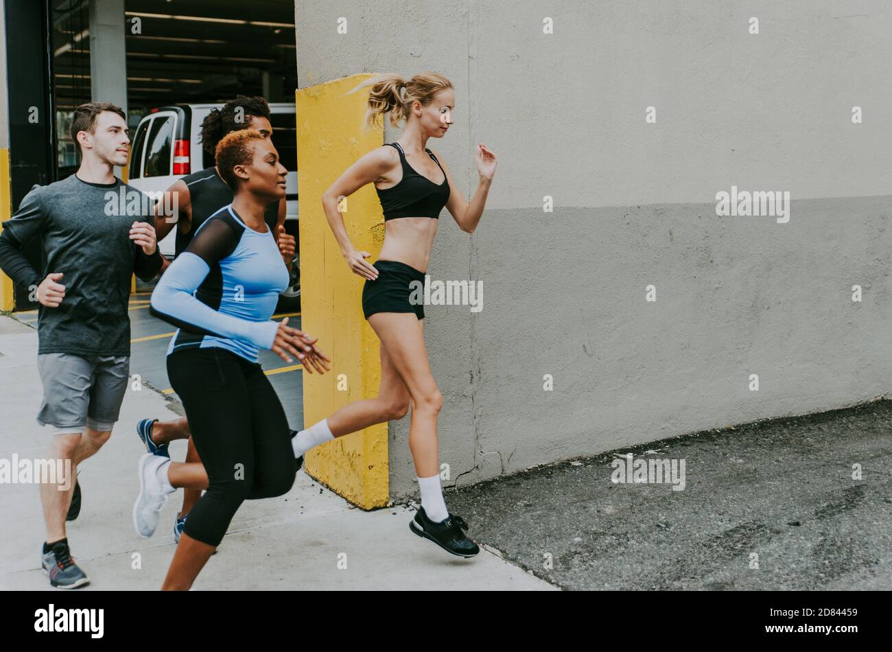 Group of urban runners running on the street in New york city ...