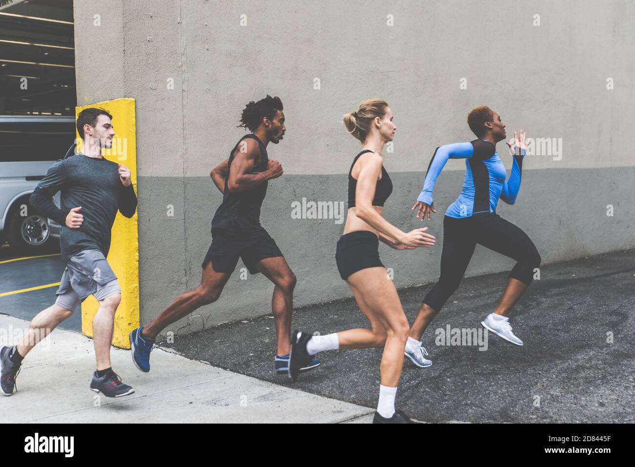 Group of urban runners running on the street in New york city ...