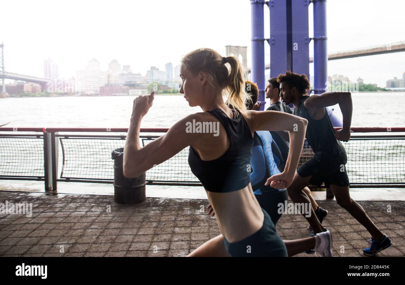 Group of urban runners running on the street in New york city ...