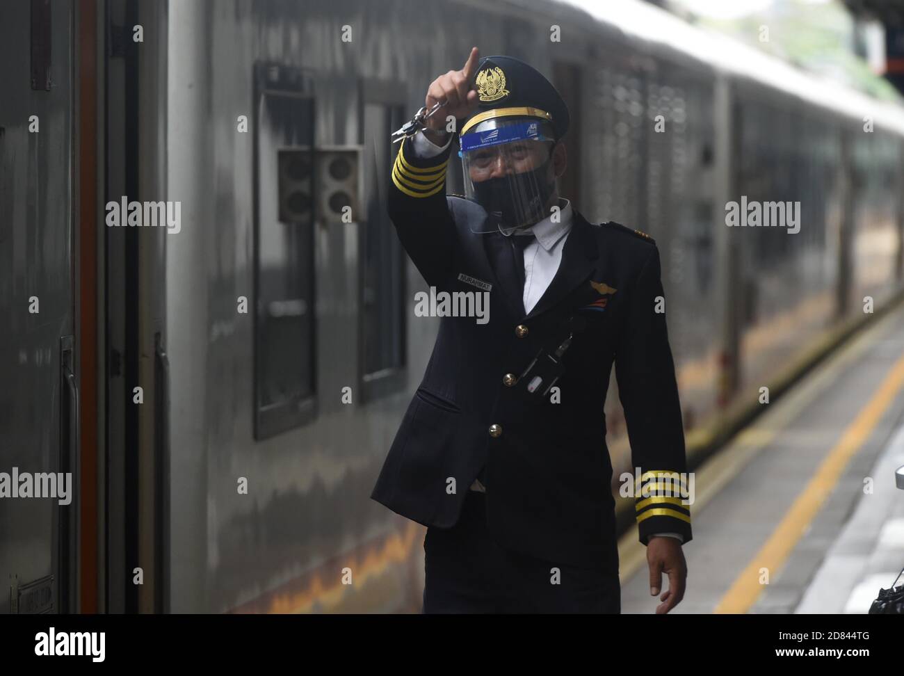 Jakarta, Indonesia. 27th Oct, 2020. A train guard wearing a face mask ...