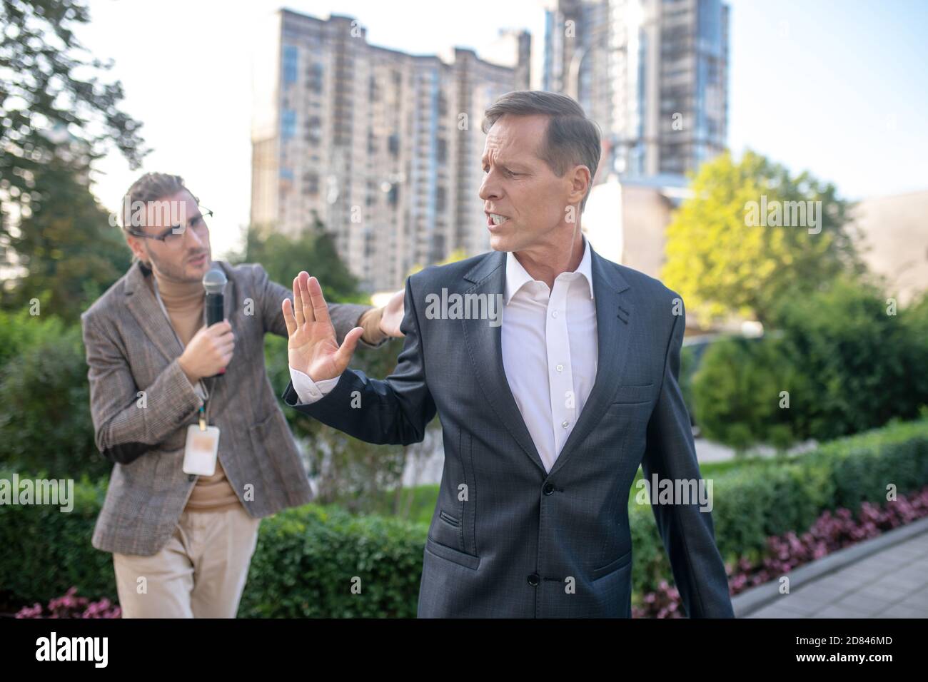 Mature man unwilling to give interview, walking away from male ...