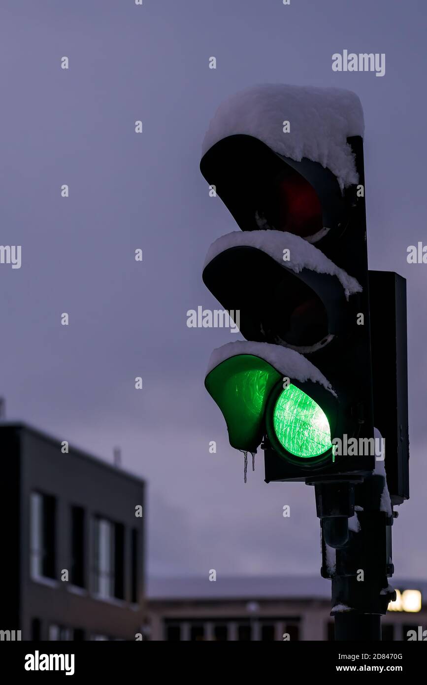 Green traffic lights covered in snow and icicle during blizzard and ...