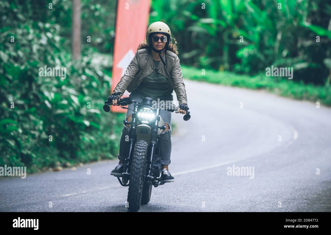 Beautiful girl having fun driving her custom cafe racer motorcycle ...