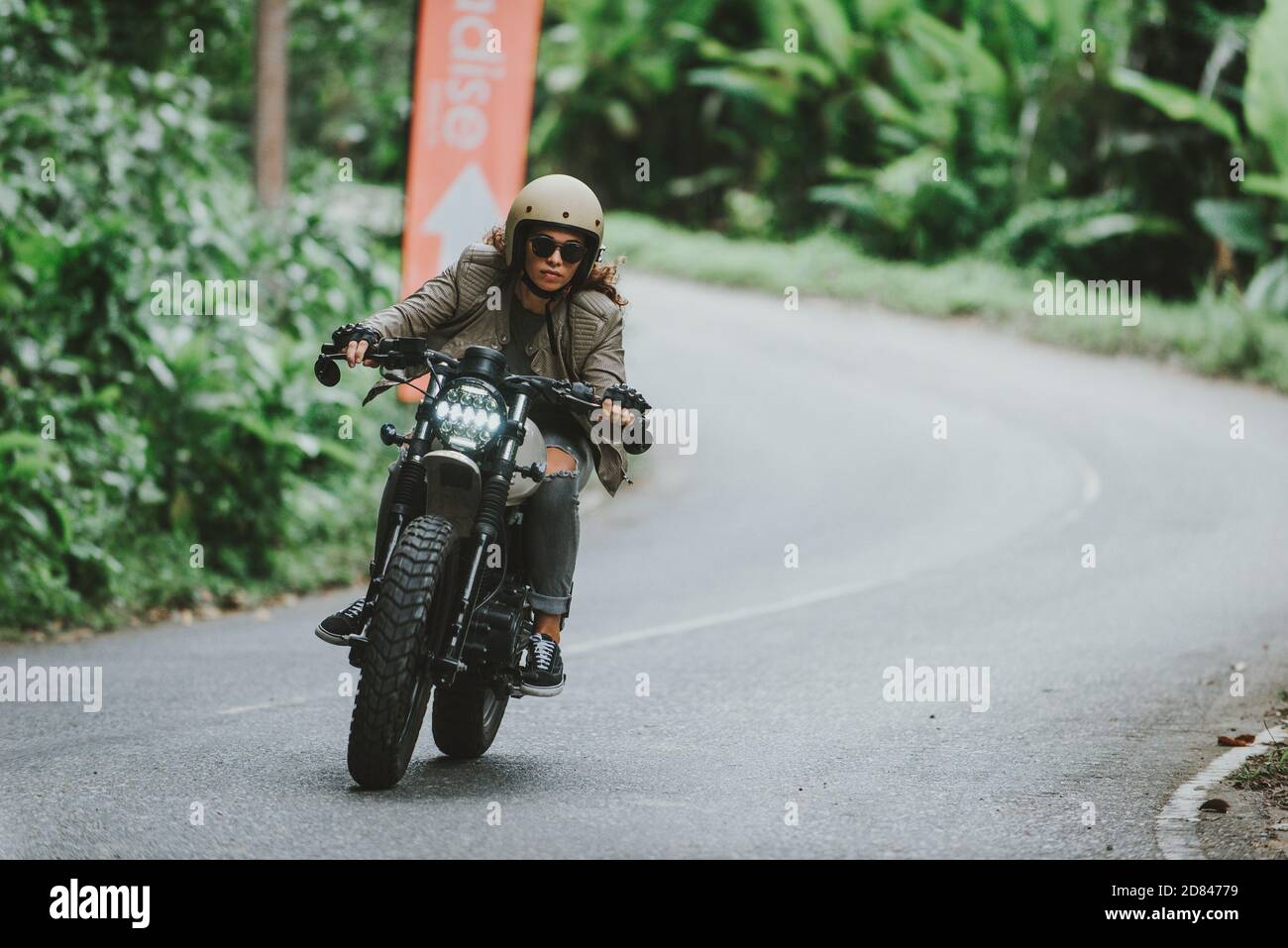 Beautiful girl having fun driving her custom cafe racer motorcycle ...