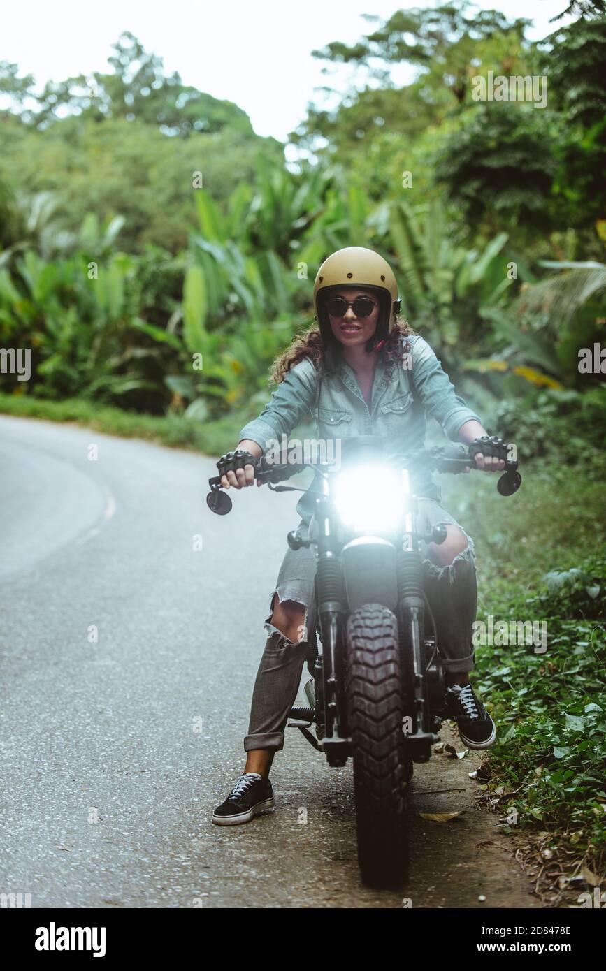 Beautiful girl having fun driving her custom cafe racer motorcycle ...