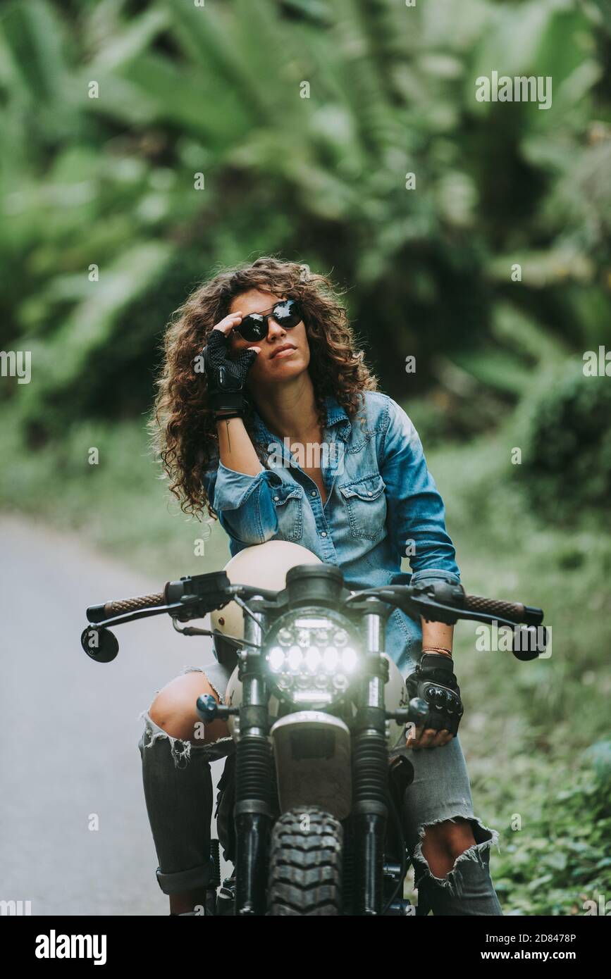 Beautiful girl having fun driving her custom cafe racer motorcycle ...