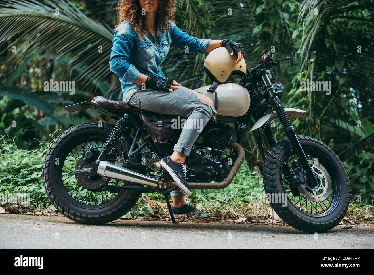 Beautiful girl having fun driving her custom cafe racer motorcycle ...