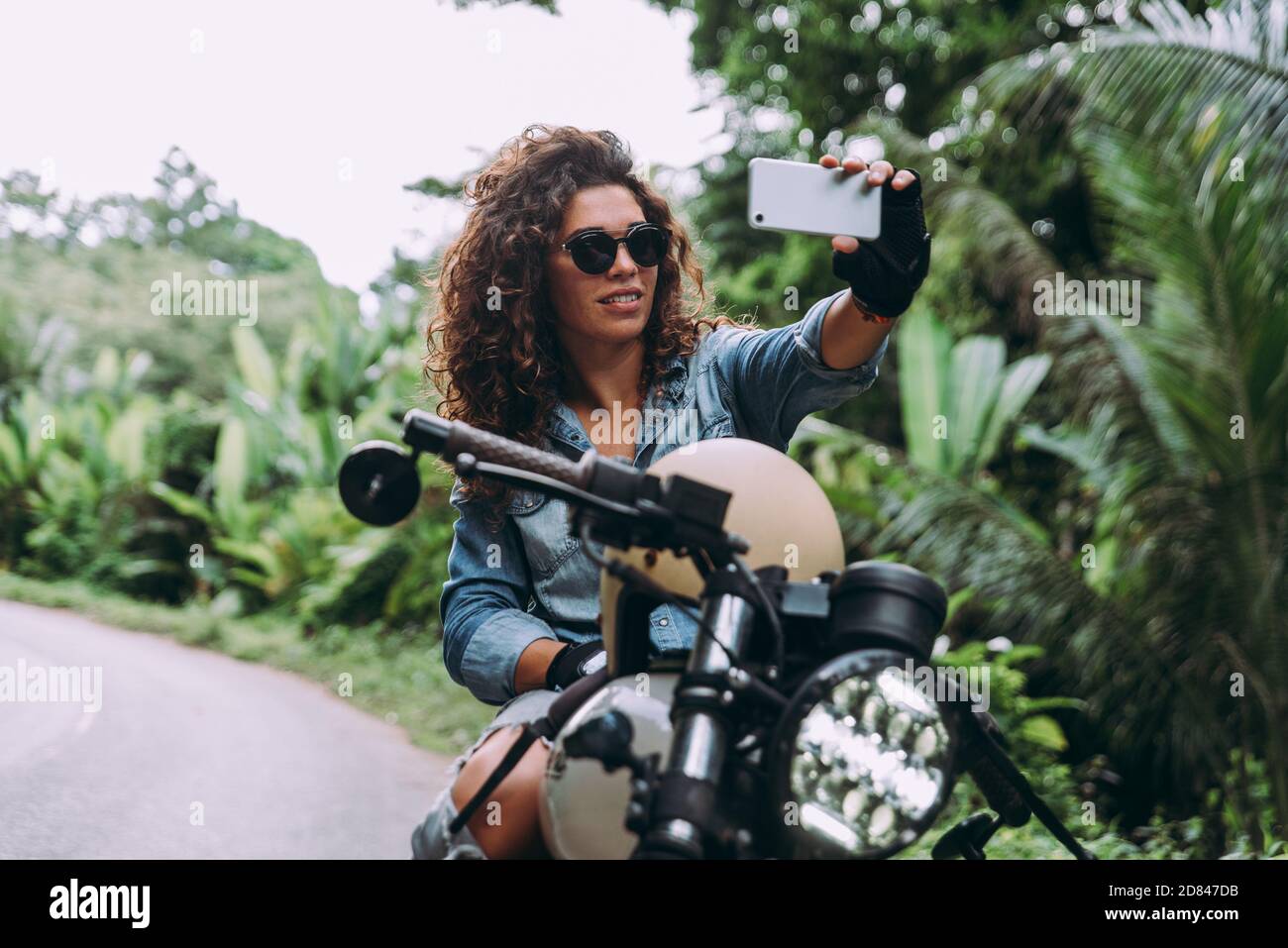 Beautiful girl having fun driving her custom cafe racer motorcycle ...