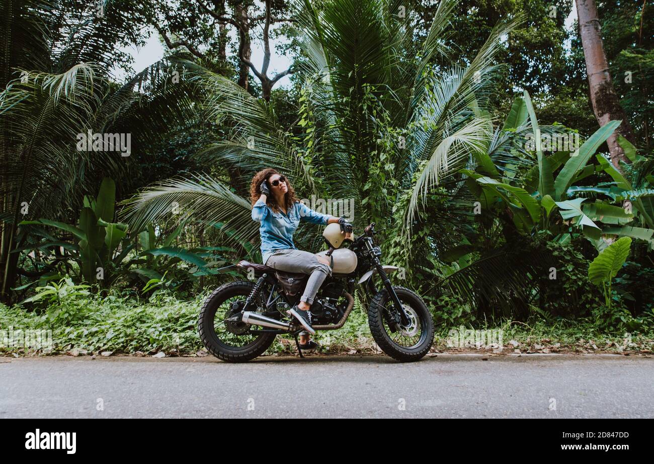 Beautiful girl having fun driving her custom cafe racer motorcycle ...
