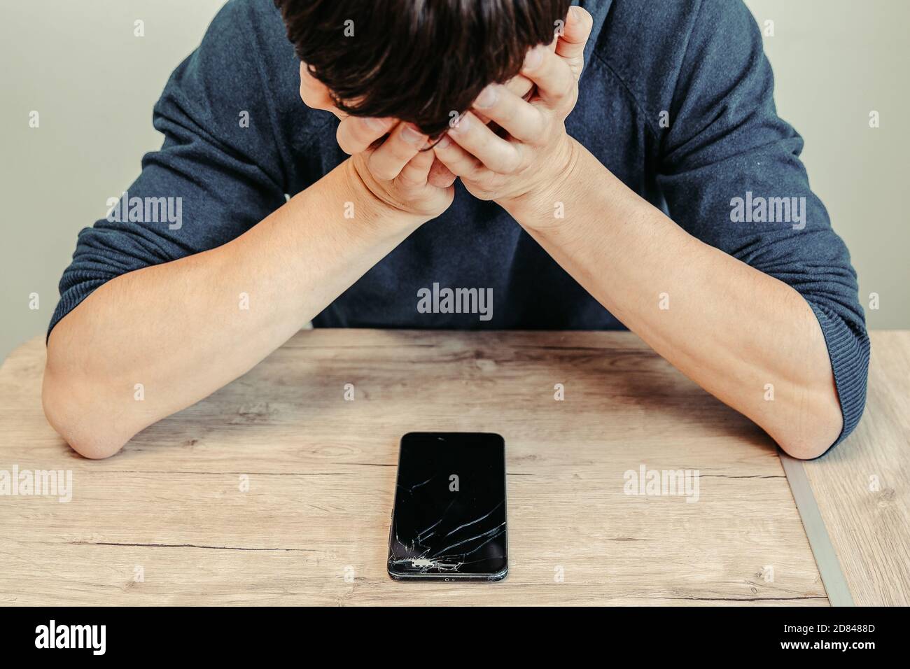 frustrated young man looking at his broken smartphone Stock Photo - Alamy