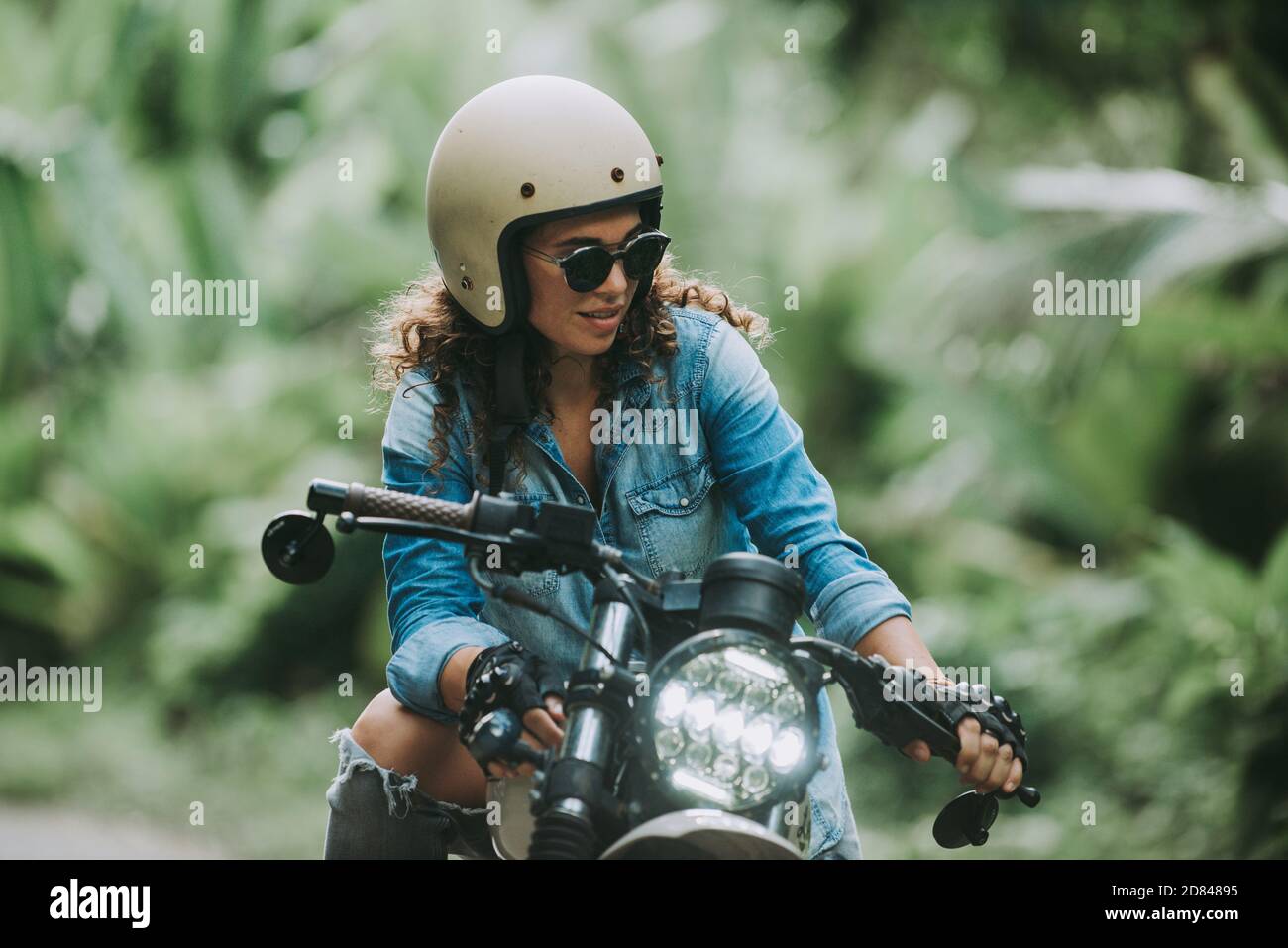 Beautiful girl having fun driving her custom cafe racer motorcycle ...