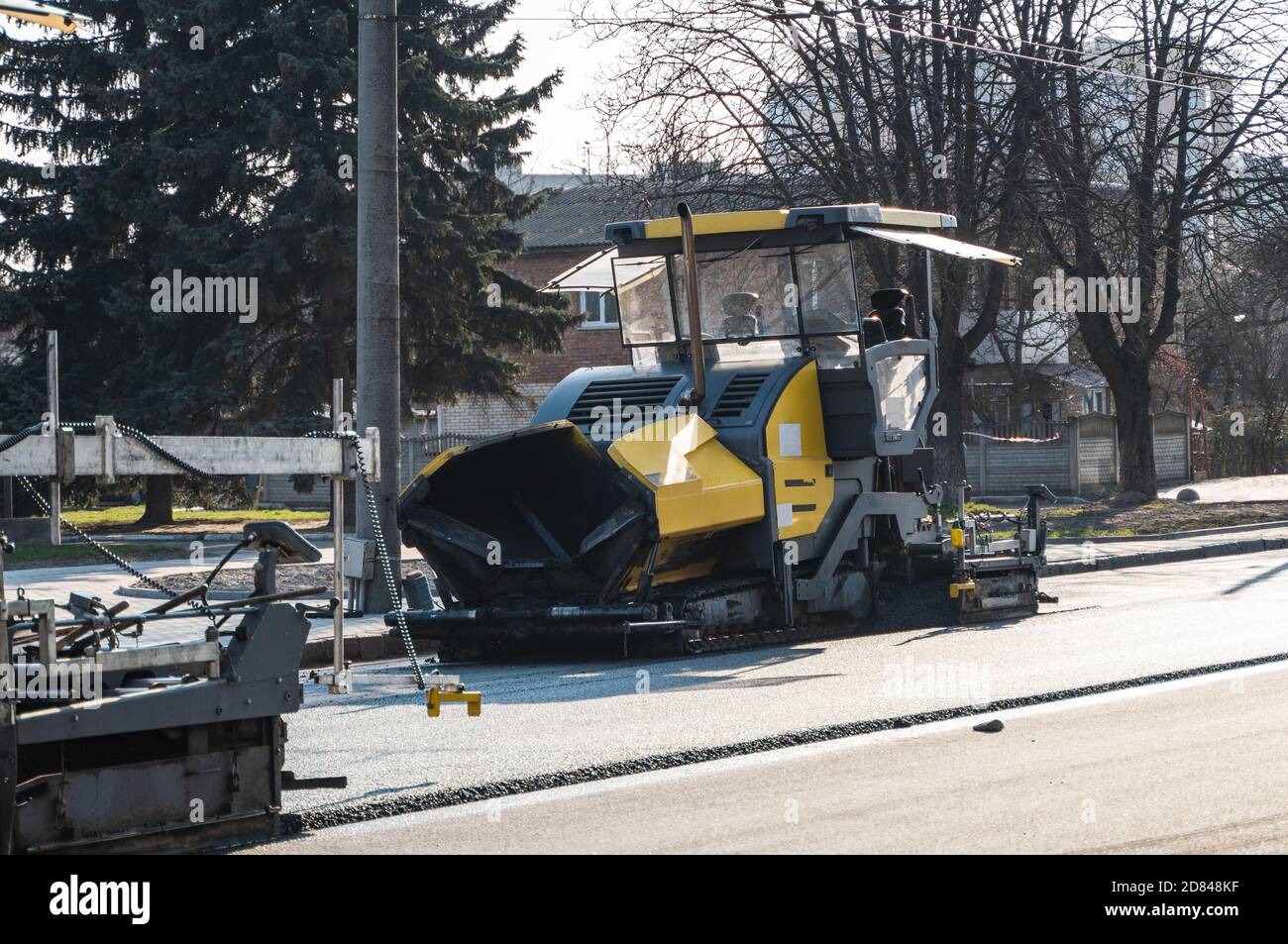 Industrial asphalt paver machine laying fresh asphalt on road ...