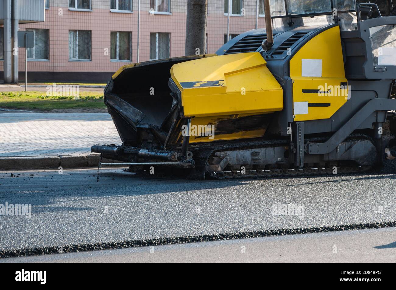 Industrial asphalt paver machine laying fresh asphalt on road ...