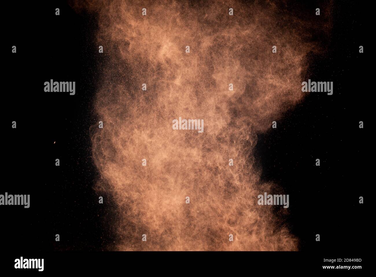 Flying cocoa powder on isolated black background, brown chocolate dust ...