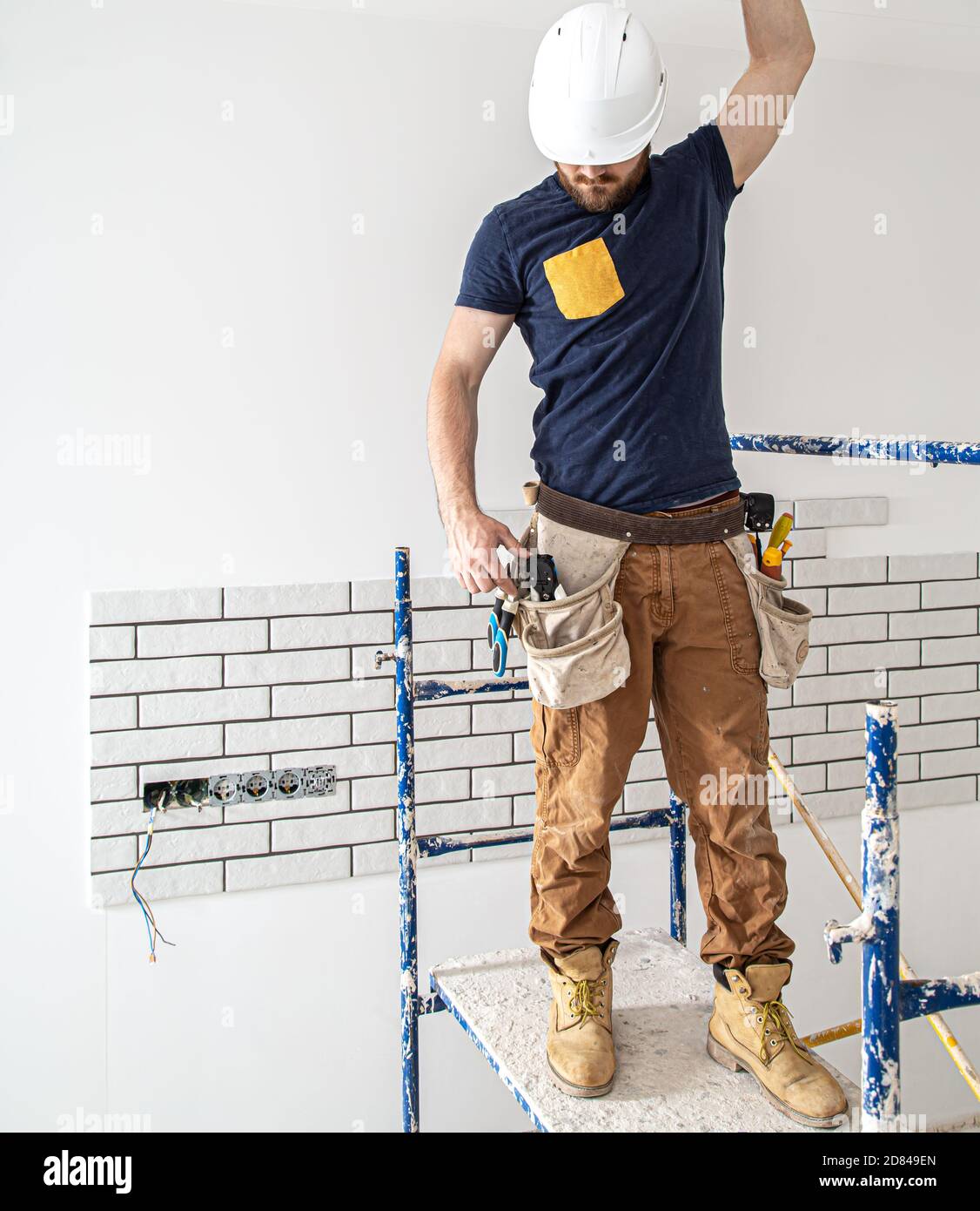 Electrician Builder at work, installation of lamps at height ...