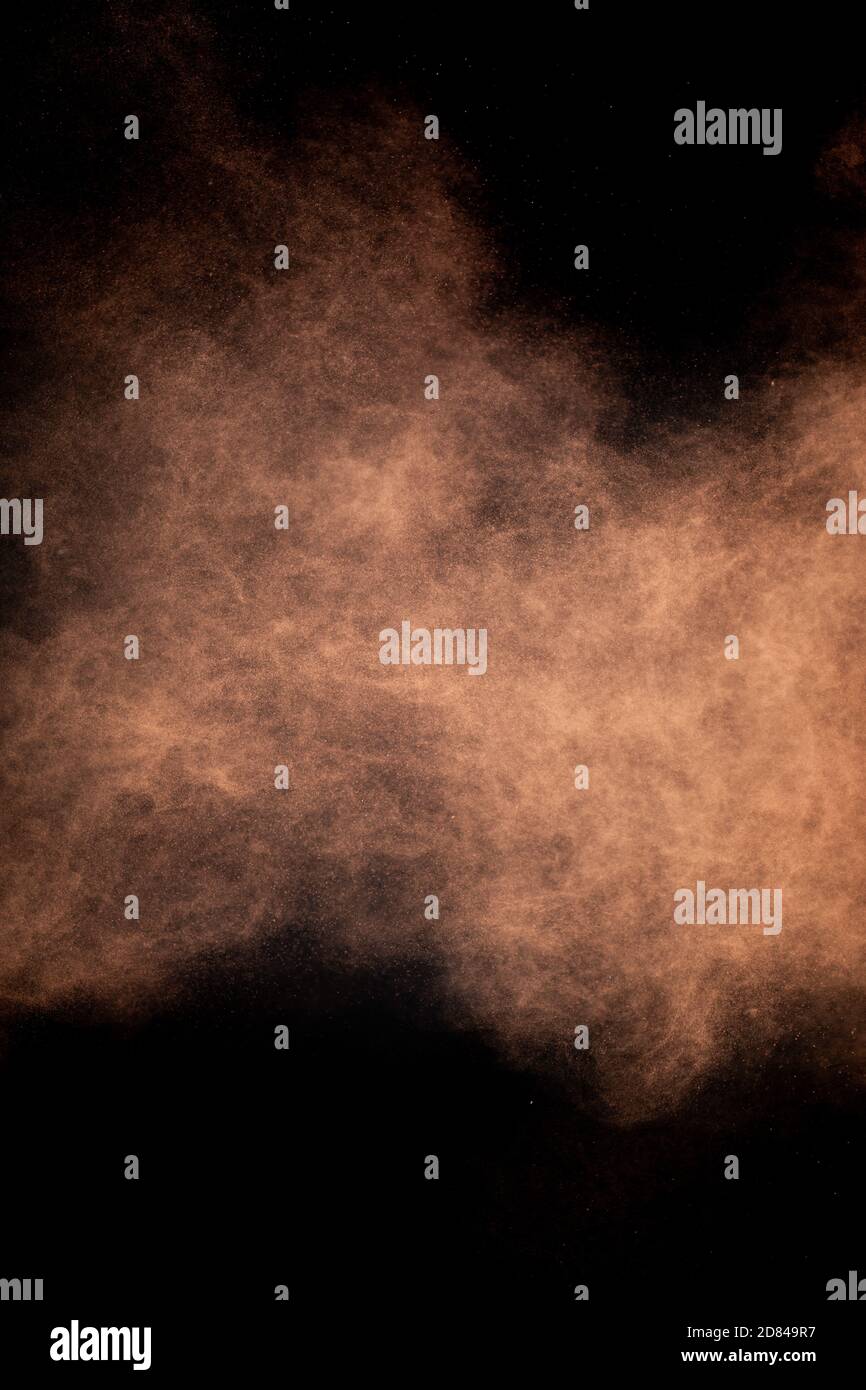 Flying cocoa powder chocolate dust cloud on isolated black background ...