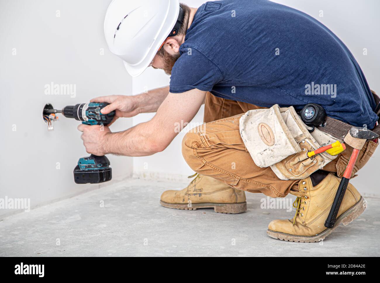 Electrician Builder at work, installation of lamps at height ...