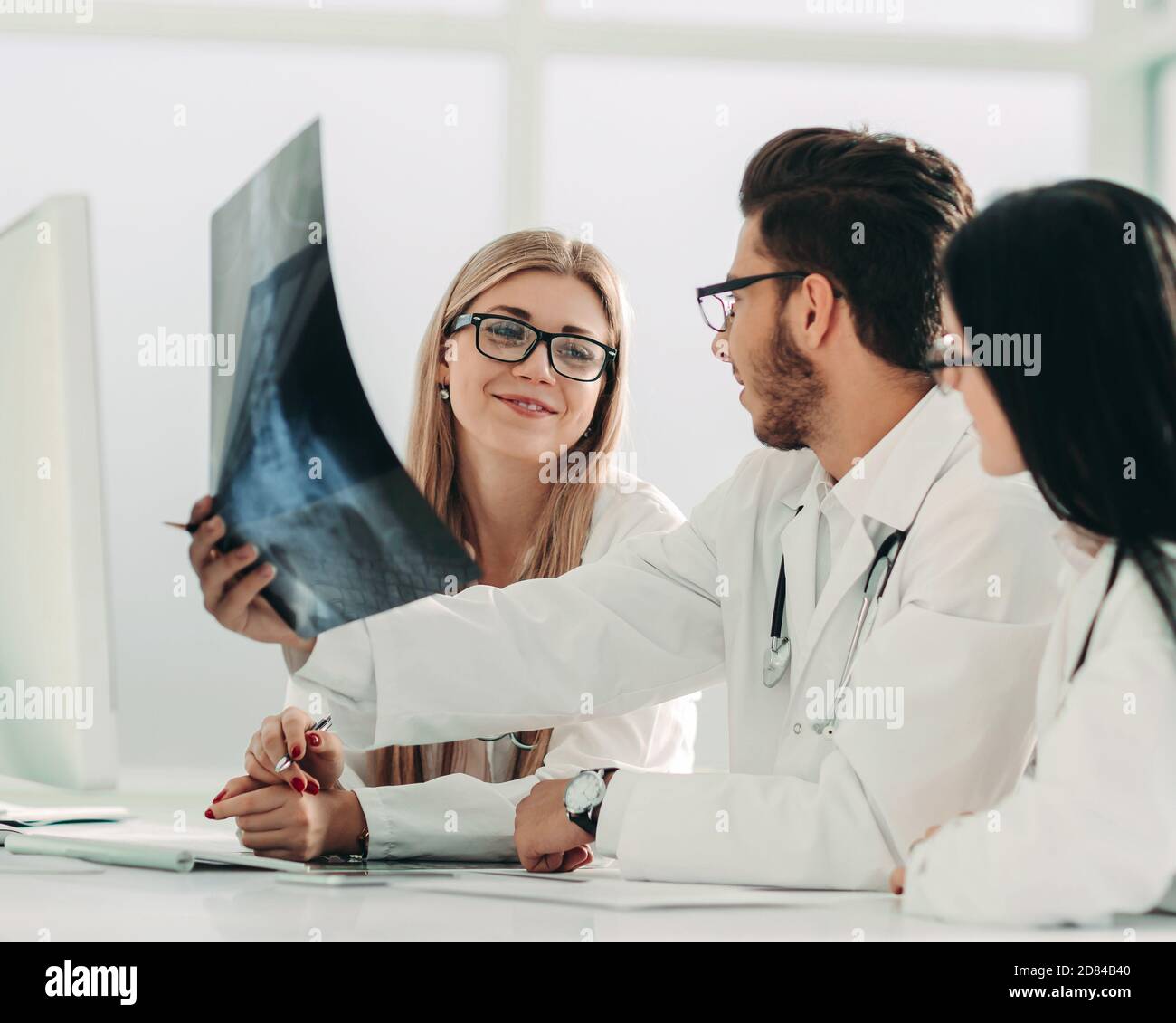 radiologist and his colleagues discuss the x-ray of the patient Stock ...