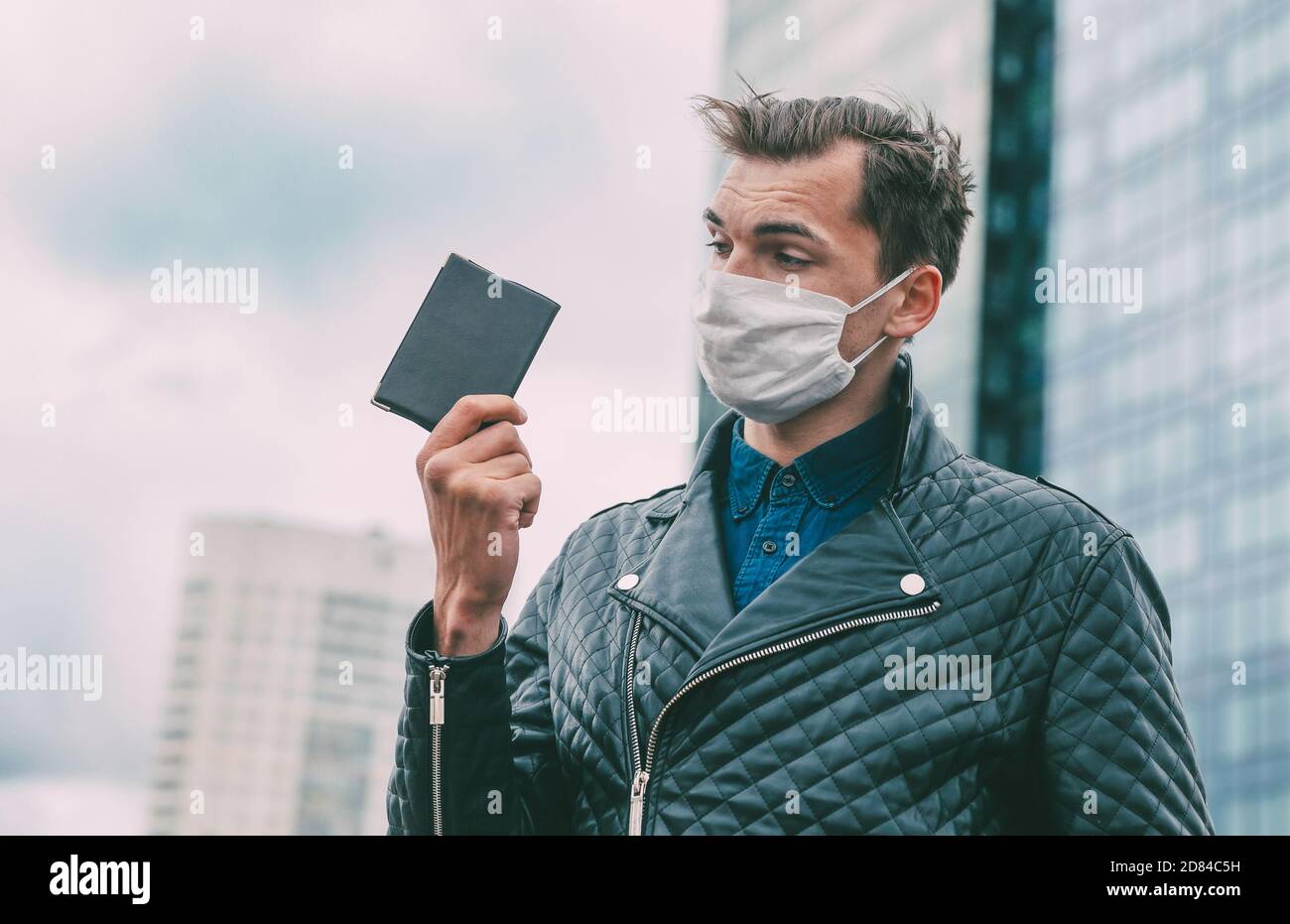 young man in a protective mask showing his passport Stock Photo - Alamy