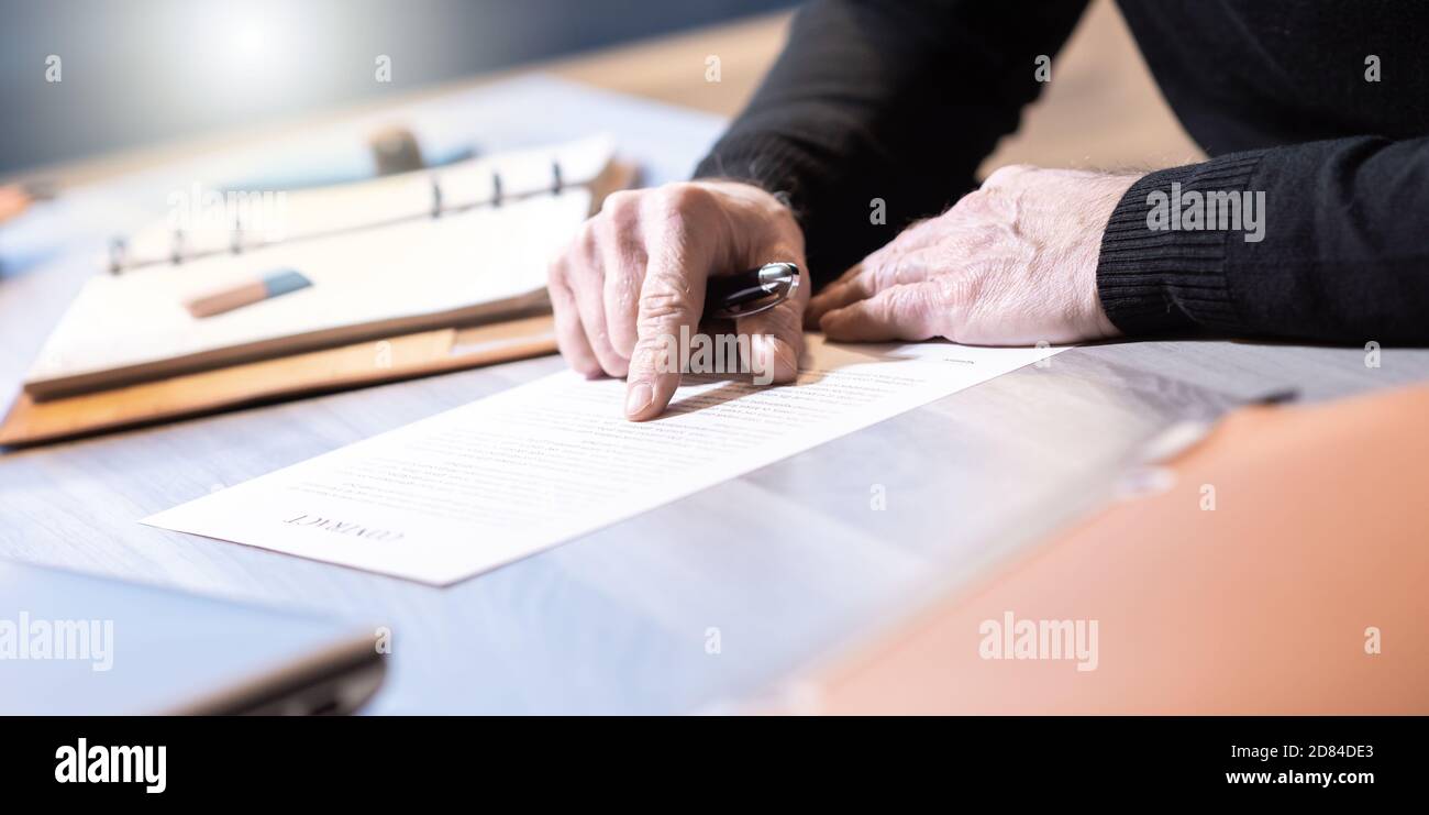 Senior businessman reviewing terms of contract at office Stock Photo ...