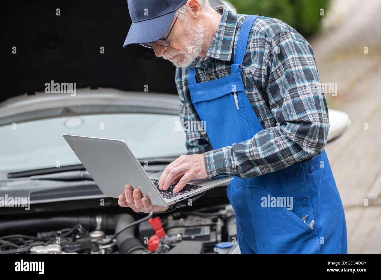 Car mechanic using laptop for checking car engine Stock Photo - Alamy