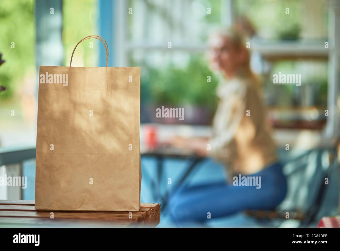 Paper packet on table on business woman background Stock Photo - Alamy
