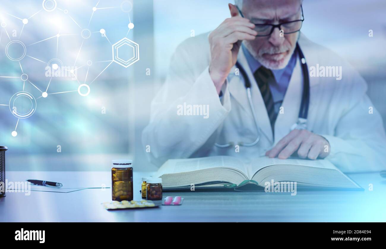 Senior doctor reading a textbook in medical office; light effect Stock ...