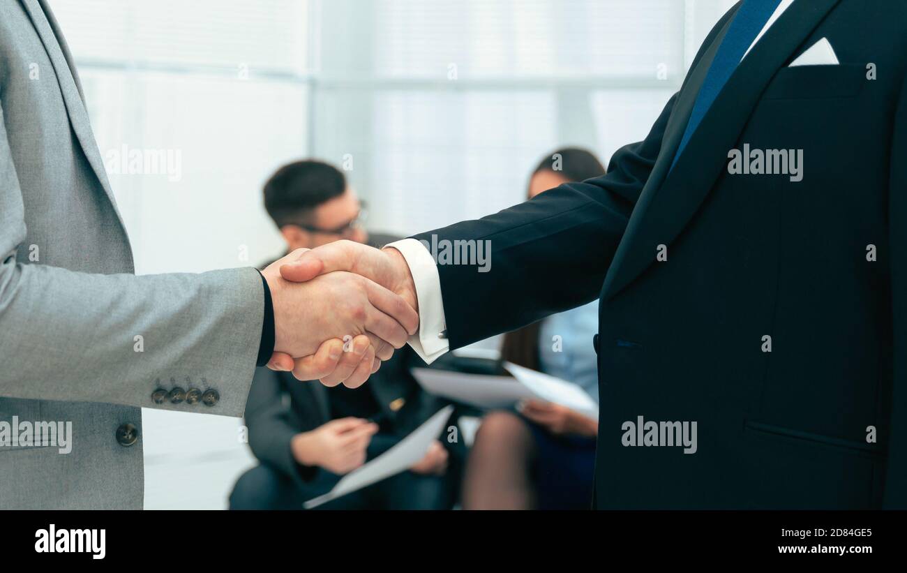 side view. serious business partners shaking hands Stock Photo - Alamy