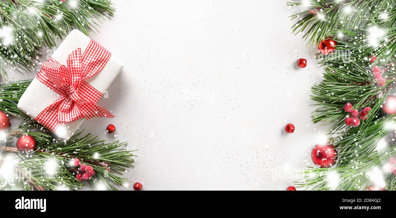 Snowy festive Christmas banner with red gift, evergreen branches on ...