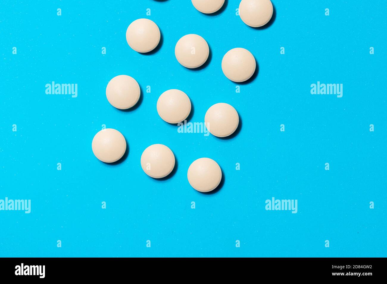 white round tablets on a blue background Stock Photo - Alamy