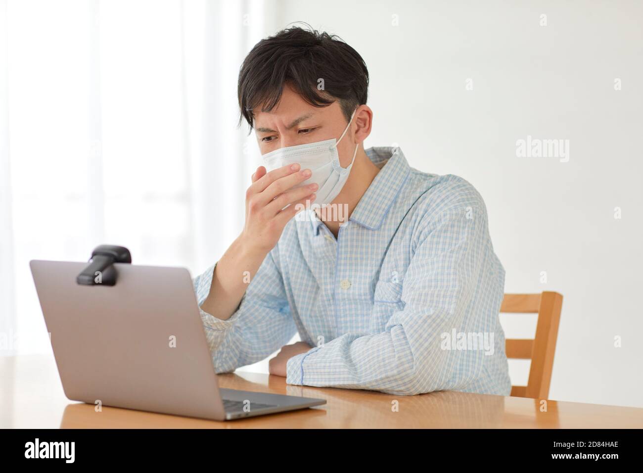 Sick Japanese man working from home Stock Photo - Alamy