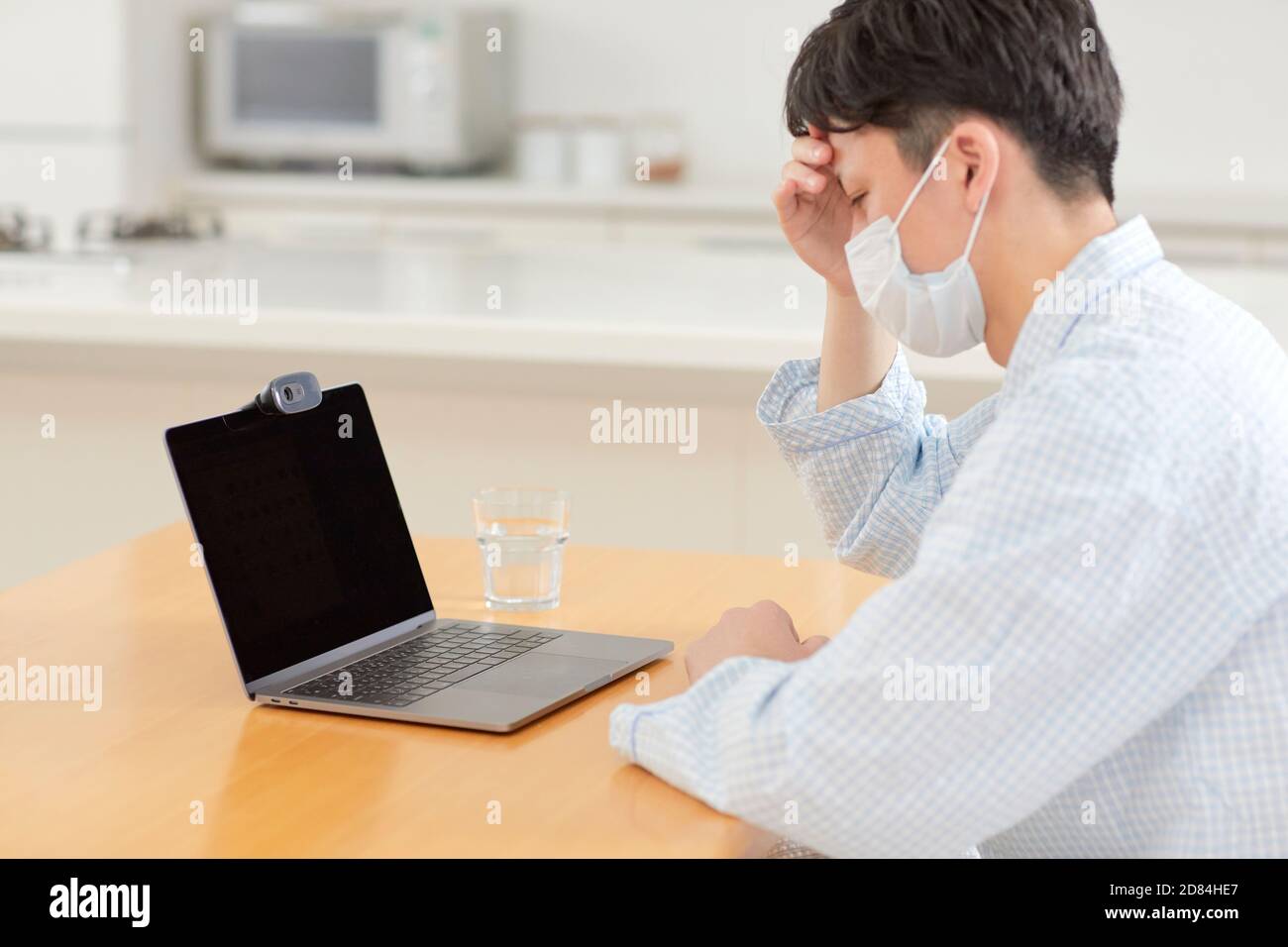 Sick Japanese man working from home Stock Photo - Alamy