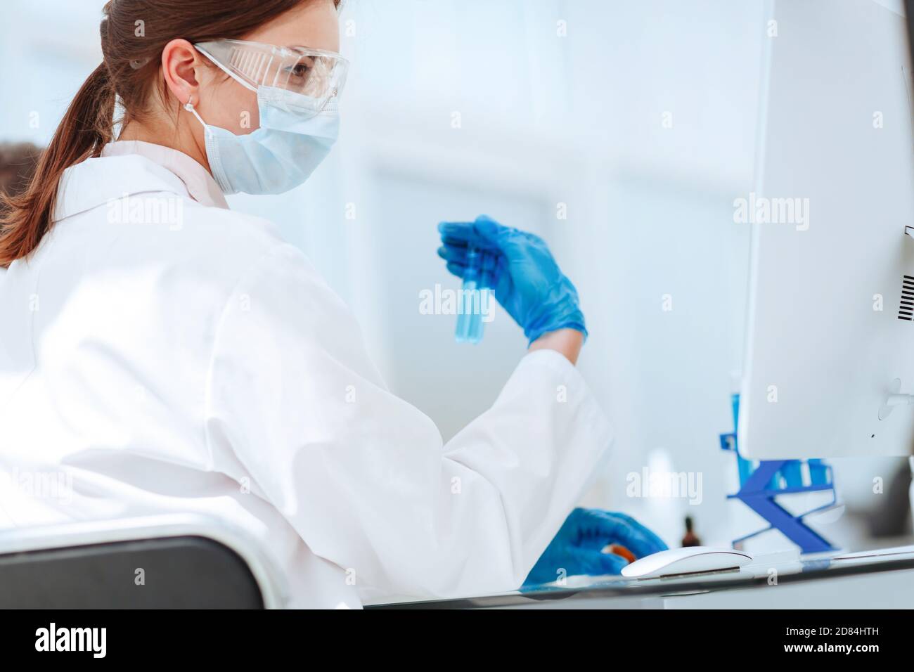 close up .female scientist looking at test tube Stock Photo - Alamy