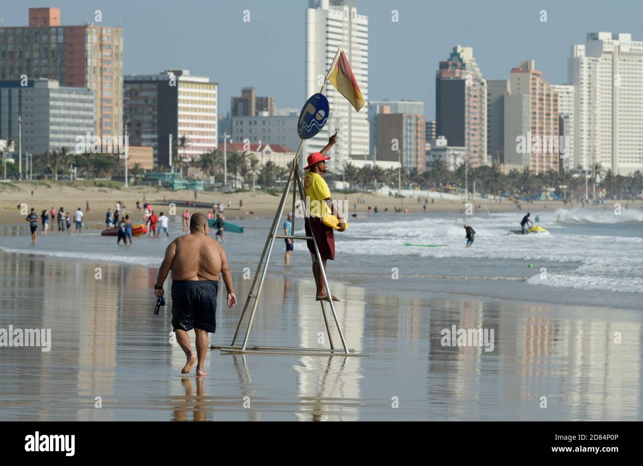 Fat adult man walking on beach, lifeguard watching people swimming ...