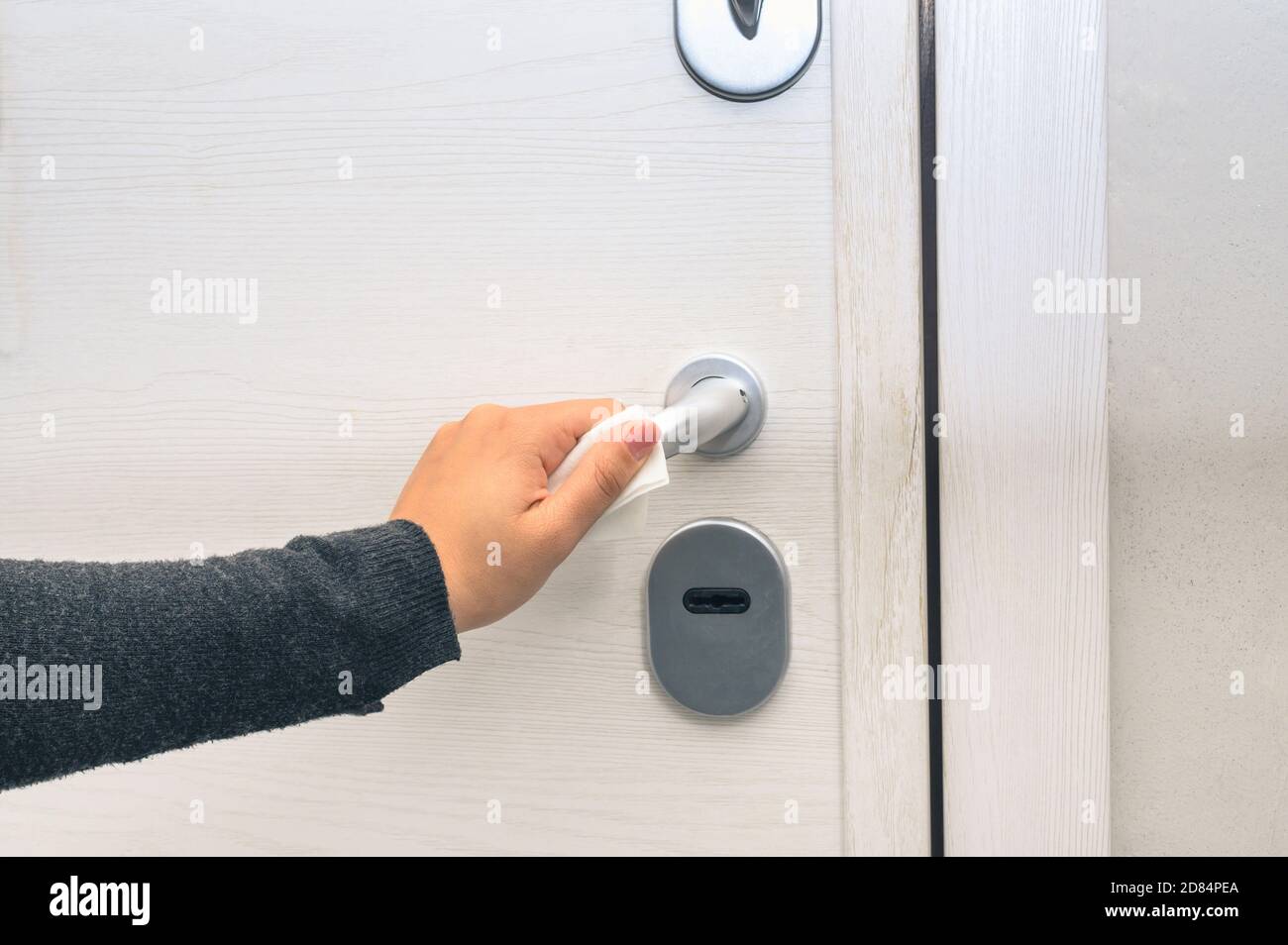 Woman open the door doorknob with wipe for don't touching surfaces ...