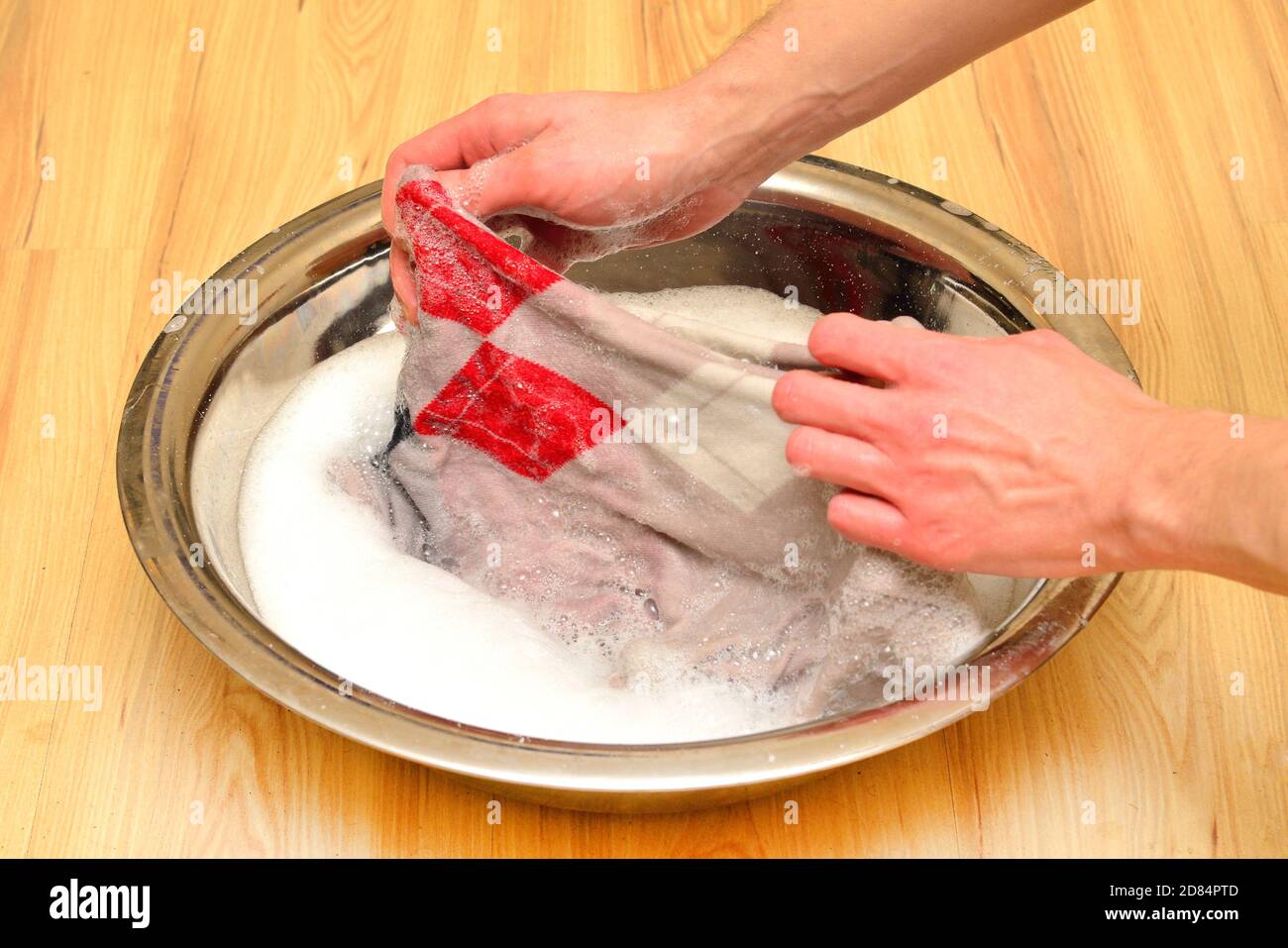 Hands show how to wash clothes and remove stains with washing powder ...